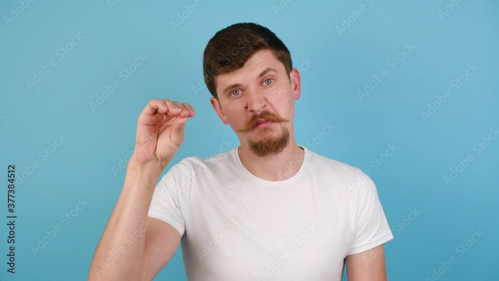 Vidéo Stock Displeased young man showing nonsense gesture, gossips ...