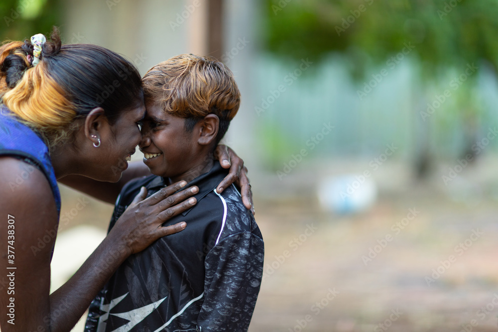 mother squashing her face up close to her son with blurred background ...