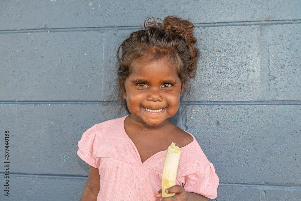 Aboriginal girl eating banana Stock Photo | Adobe Stock