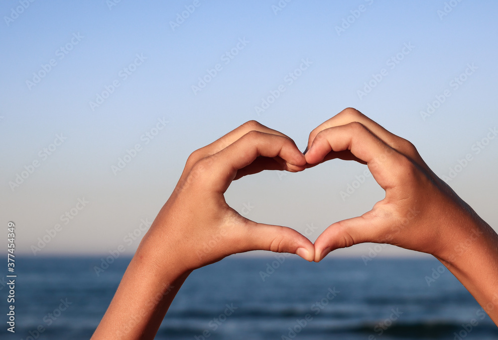 heart shape in hands. Heart shape in hands against a background of blue ...