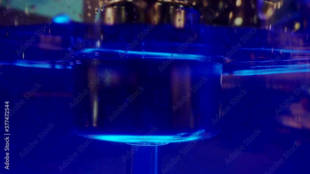 submersible float in a transparent glass tube filled with illuminated ...