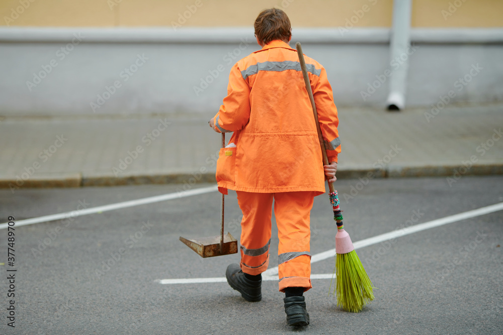 Street sweeper cleaning road. Municipal worker in orange uniform ...