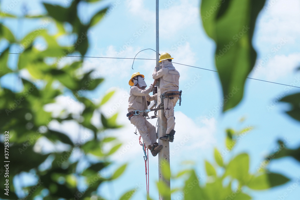 Electrical experts are on the power poles to install steel brackets for ...