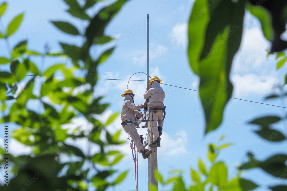 Electrical experts are on the power poles to install steel brackets for ...