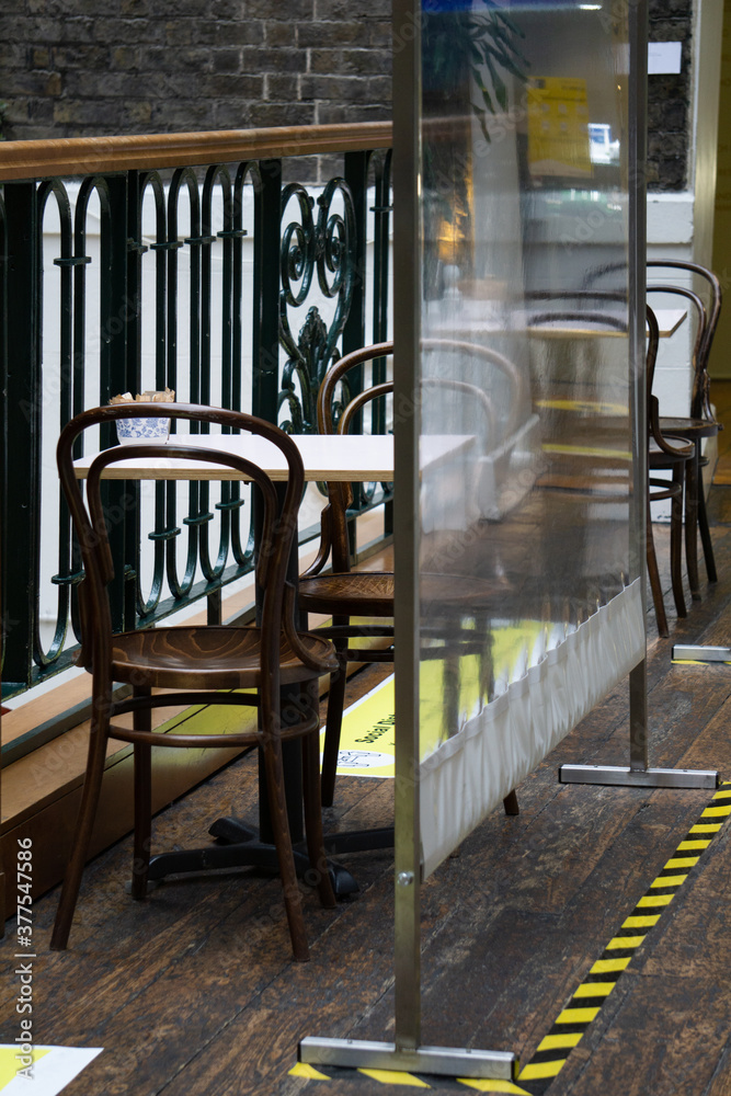 Covid19 dining out with barriers between tables Stock Photo | Adobe Stock