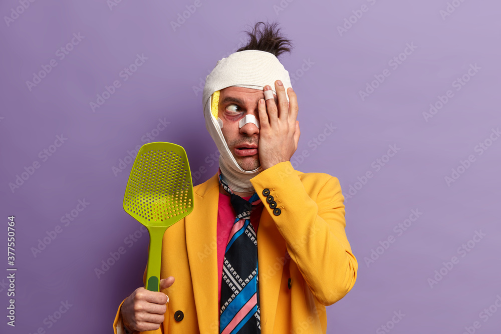 Injured bruised man afraids of cruel people, hides face with hand and ...