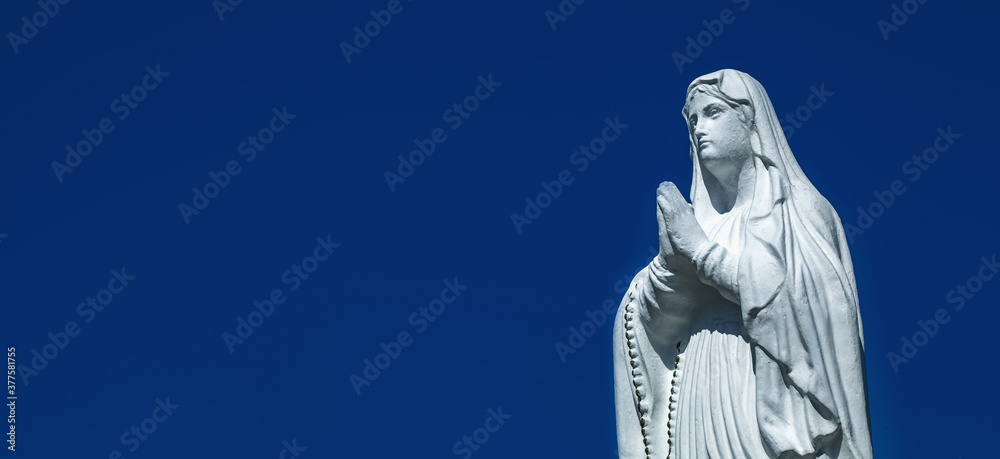 Close up ancient statue of the Virgin Mary praying. Free copy space for ...