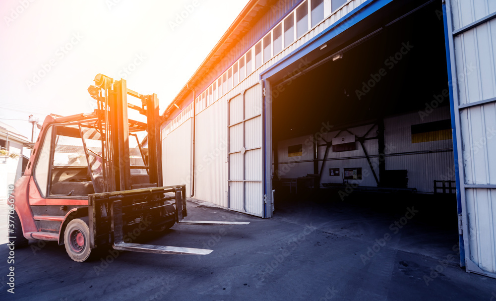The big industrial forklift drives into the warehouse. Stock Photo ...