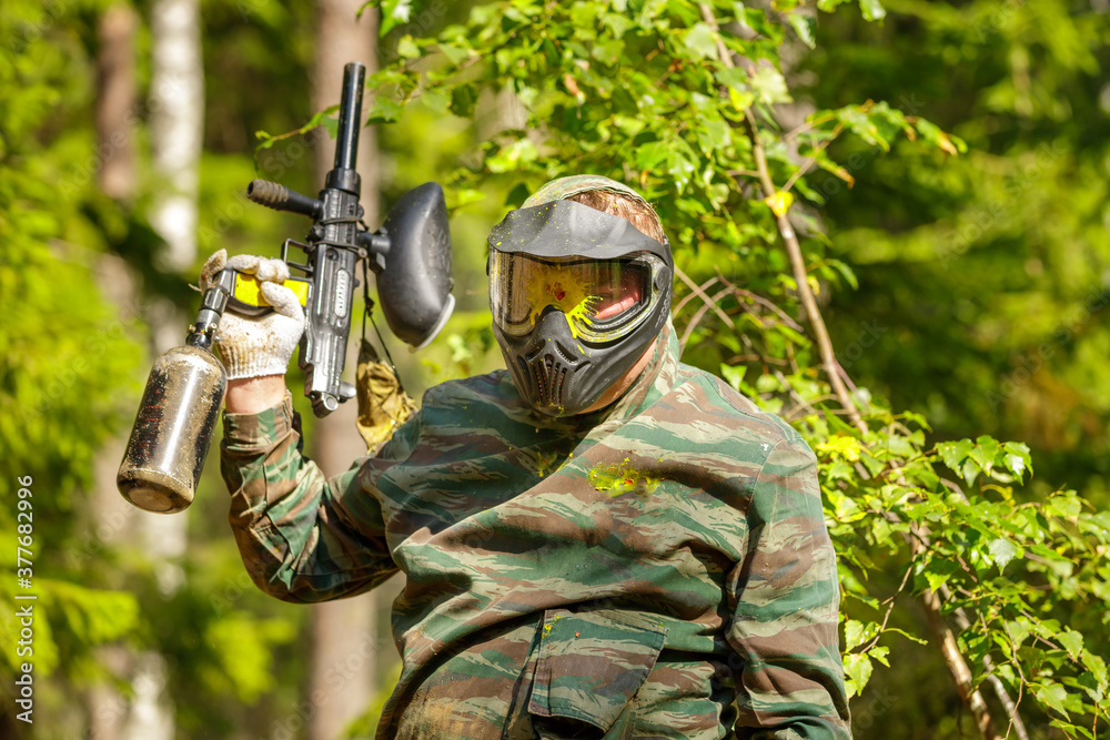 Paintball player with great paint splash on his mask posing Stock Photo ...
