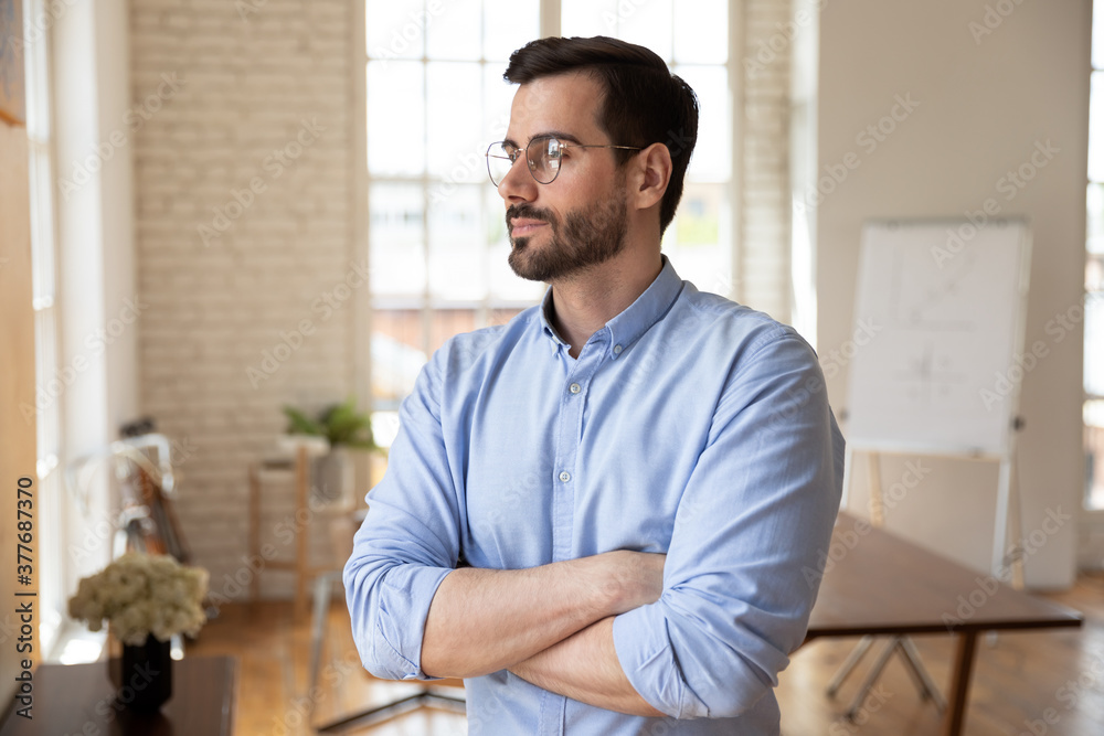 Thoughtful young Caucasian businessman stand in modern office look in ...