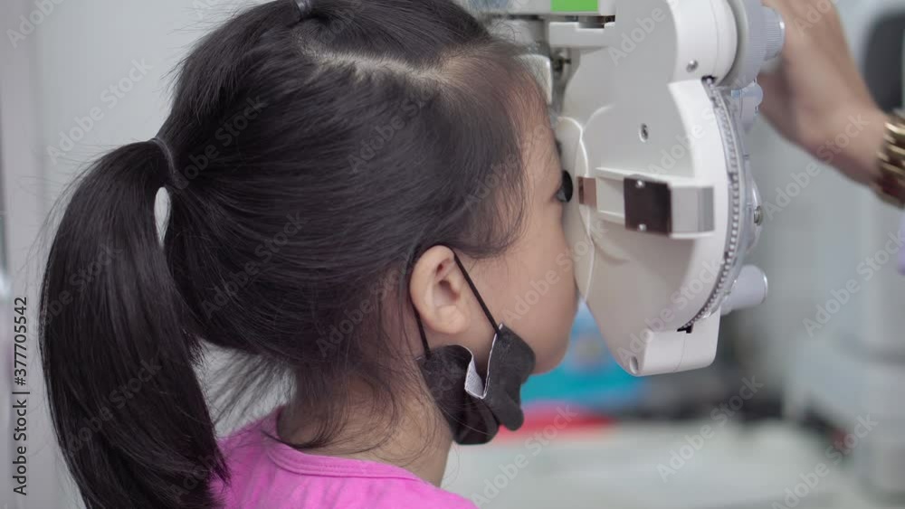 Asian kid girl an eye examination with phoropter in the clinic Stock ...