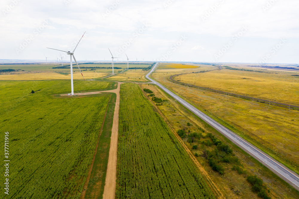 Flat terrain with lots of wind turbines in the fields and a highway ...