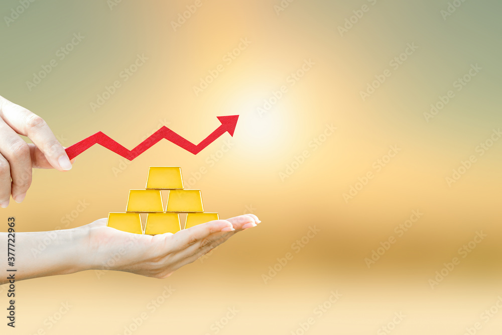 Woman hand hold a red arrow graph with growing value to the gold bar on ...