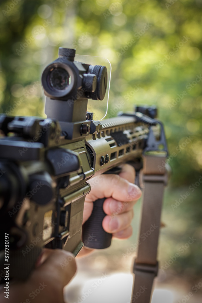Shooter aiming assault rifle at target. Stock Photo | Adobe Stock
