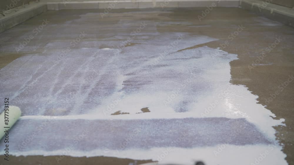 Floor repair using a primer. Priming the concrete floor with a roller ...