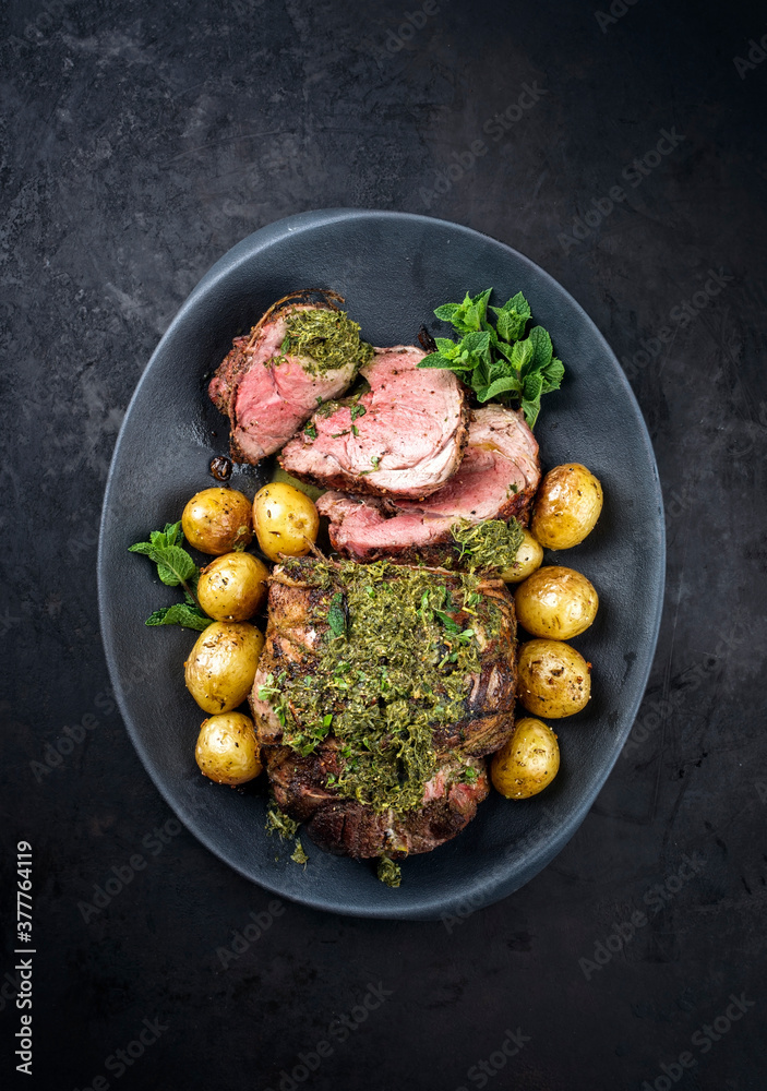 Traditional English barbecue lamb roast sliced with mint sauce and ...