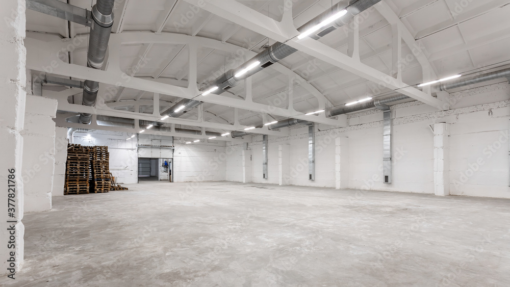 Industrial building interior with white brick walls, concrete floor and ...
