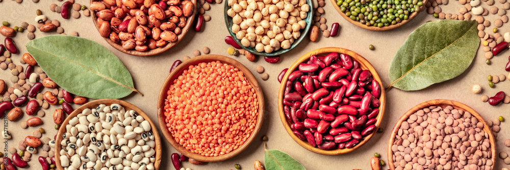 Legumes assortment, overhead panorama on a brown rustic background ...