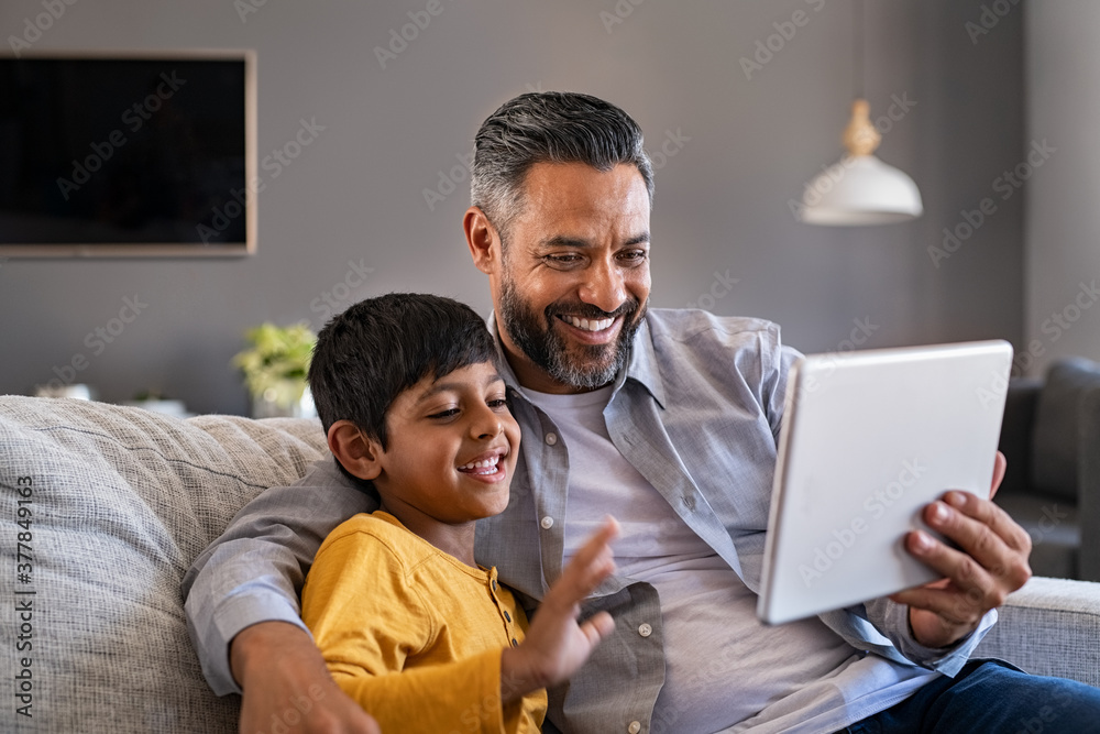 Father and son using digital tablet to make a video call Stock Photo ...
