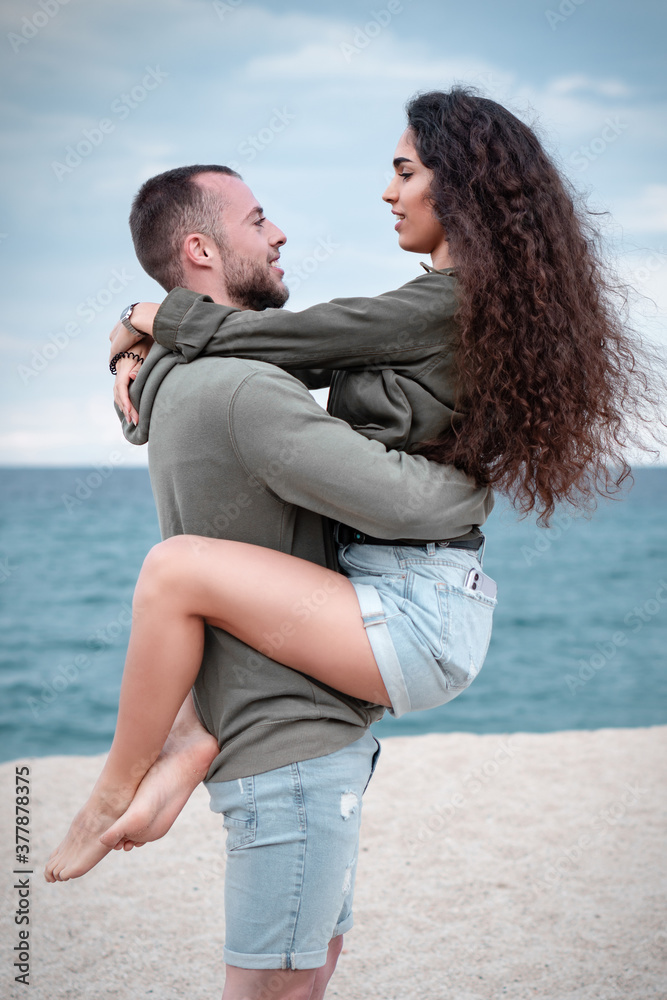 Young couple at the beach being sweet and in love. Boyfriend and ...