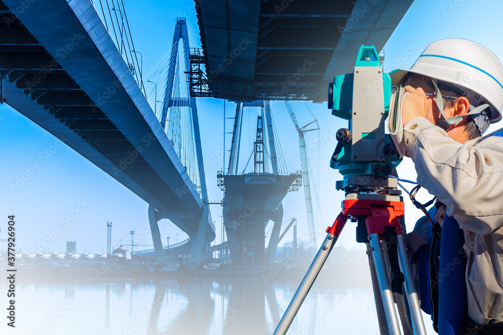 The surveyor works near the bridge. Geodesy. Geodetic measurements of ...
