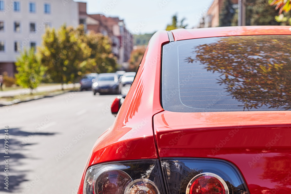 Back window of red car parked on the street in summer sunny day, rear ...