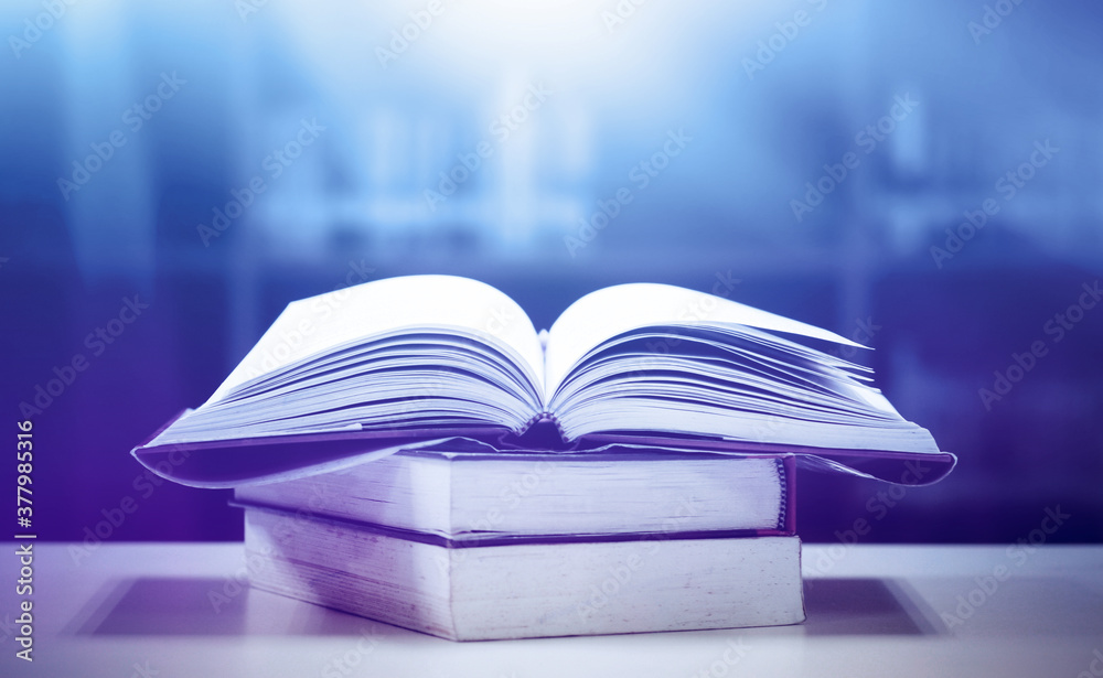 Book stack in the library and blurred bookshelf background for ...