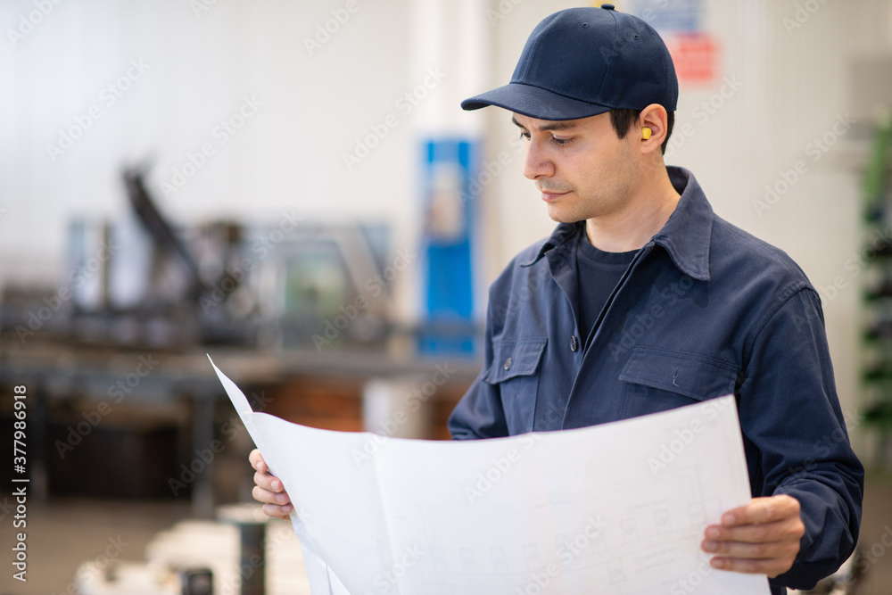 Engineer reading a bluepring drawing in a industrial facility Stock ...