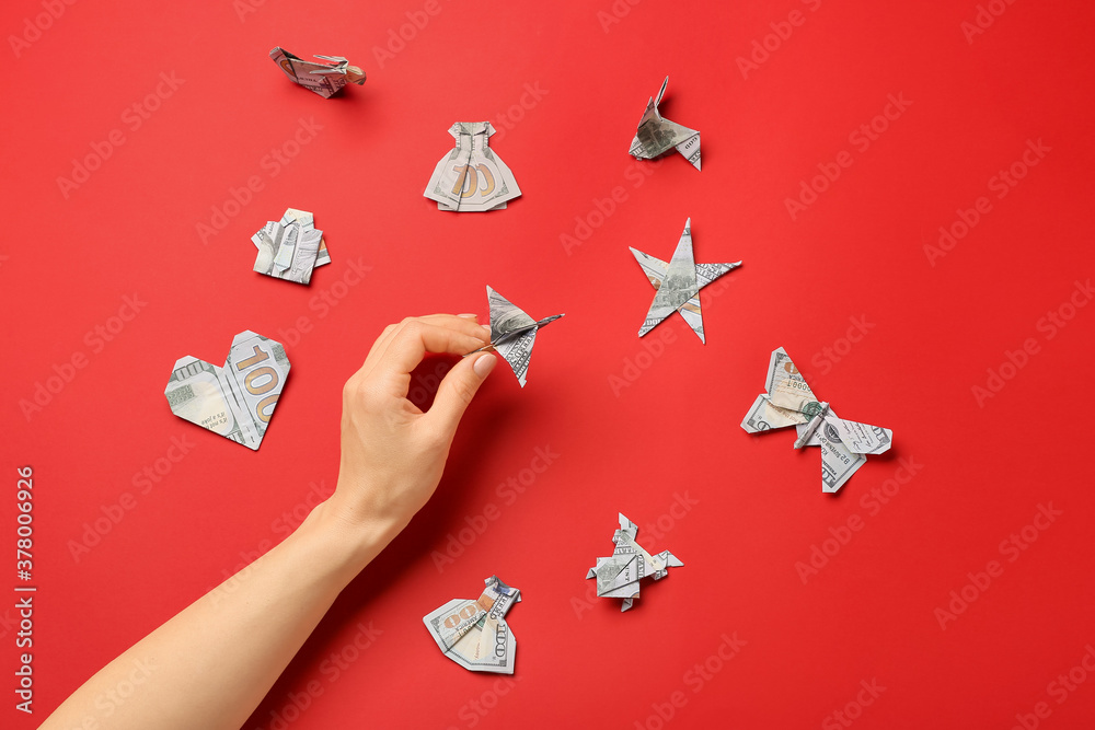 Female hand with different origami figures made from dollar banknotes ...