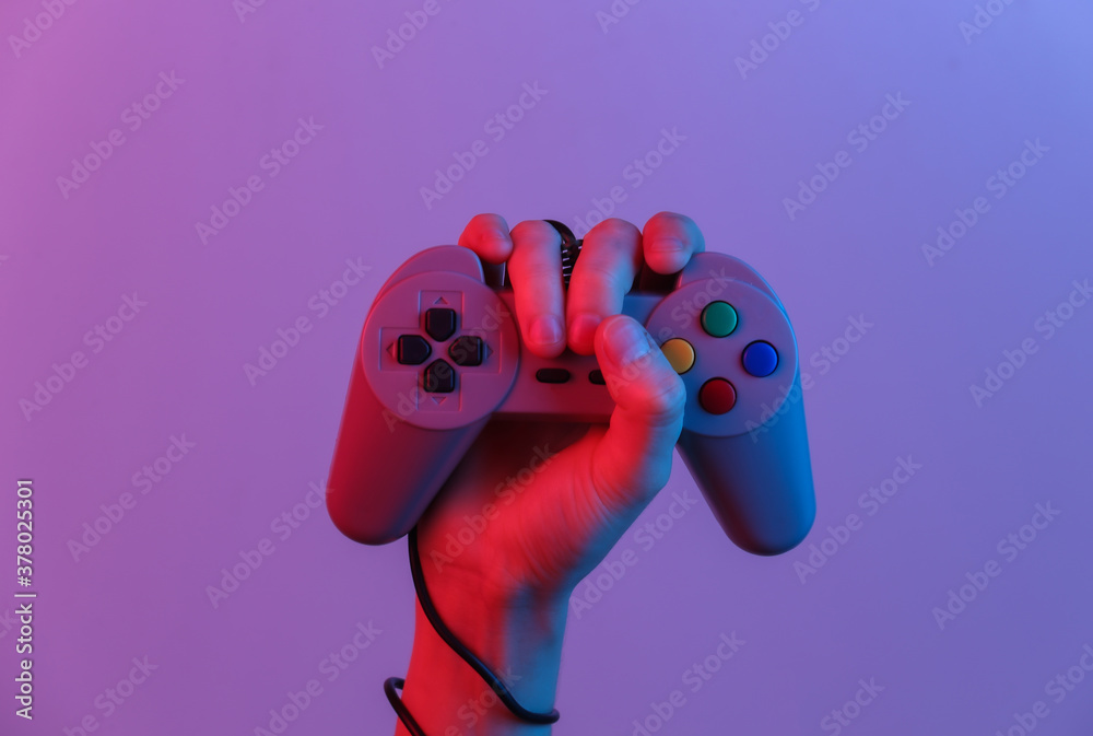 Hands holding retro joystick in blue-red neon gradient light. Old ...