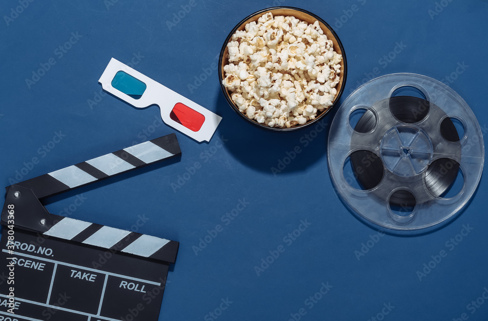 Movie clapper board, popcorn bowl, film reel and 3d glasses on classic ...