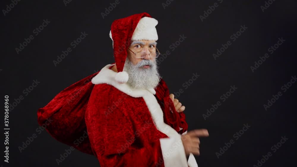 Medium shot of Santa Claus with Christmas sack walking into frame in ...