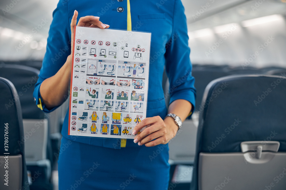 Professional flight attendant demonstrating flight safety information ...