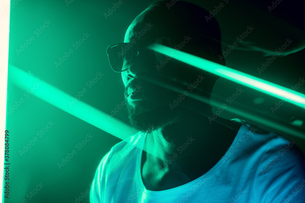 Rap star. Cinematic portrait of stylish young man in neon lighted room ...