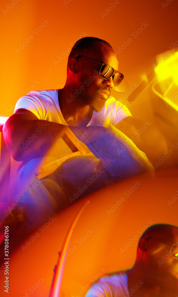 Savage. Cinematic portrait of stylish young man in neon lighted room ...