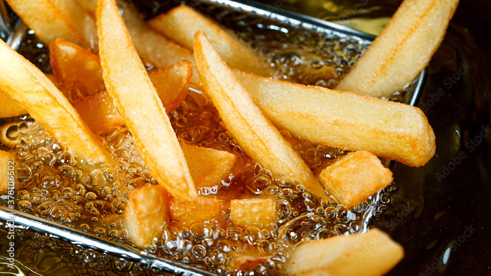 Cooking french fries in the deep fryer, crispy fries, Junk food concept ...