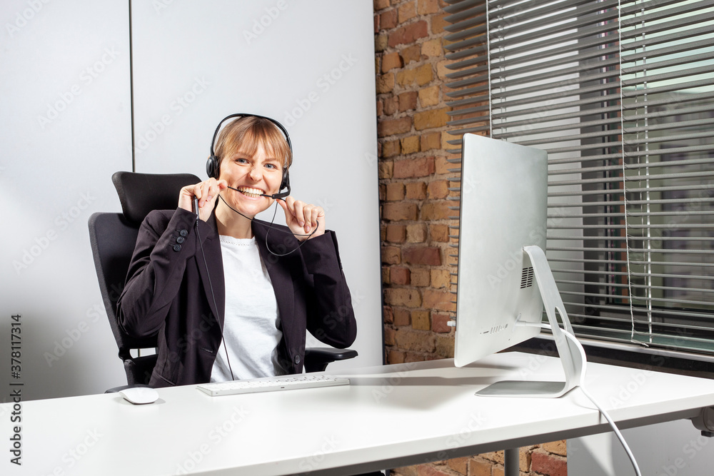 Young desperate employee working as a service consultant bites the ...