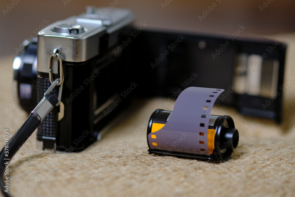 35mm film roll in front of a vintage camera Stock Photo | Adobe Stock