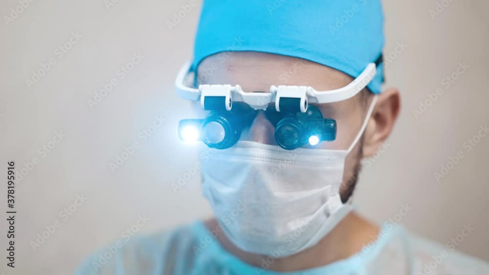 surgeon in professional glasses and uniform works in the operating room ...