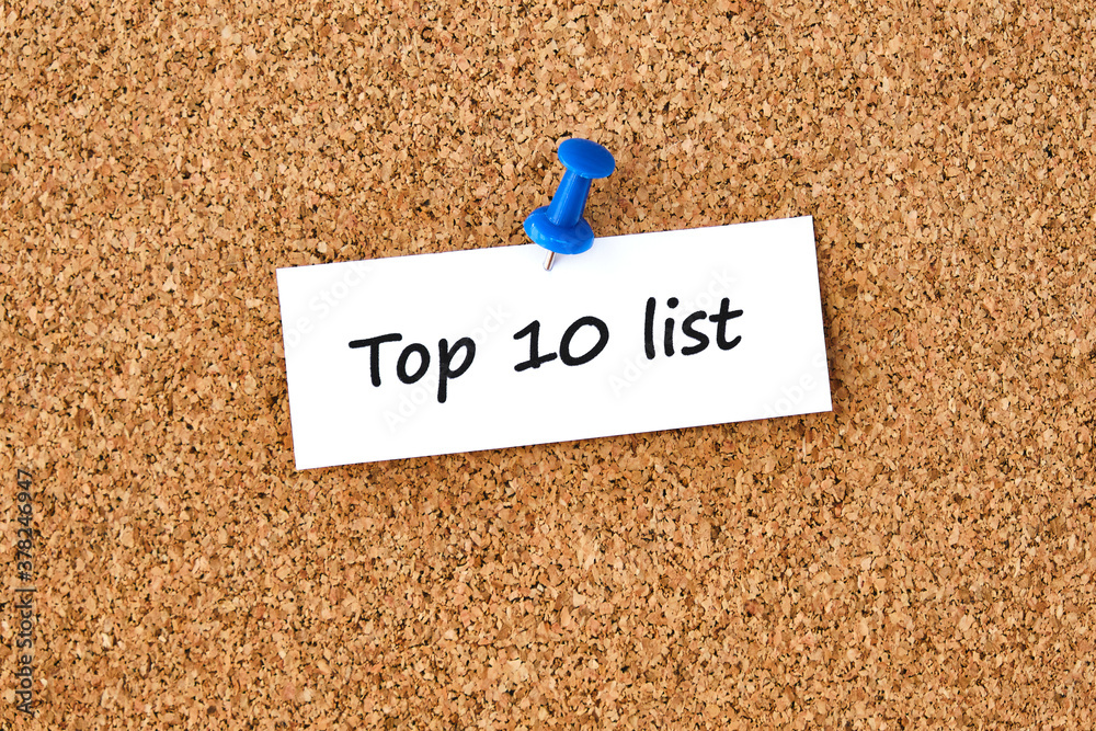 Top 10 list. Text written on a piece of paper, cork board background ...