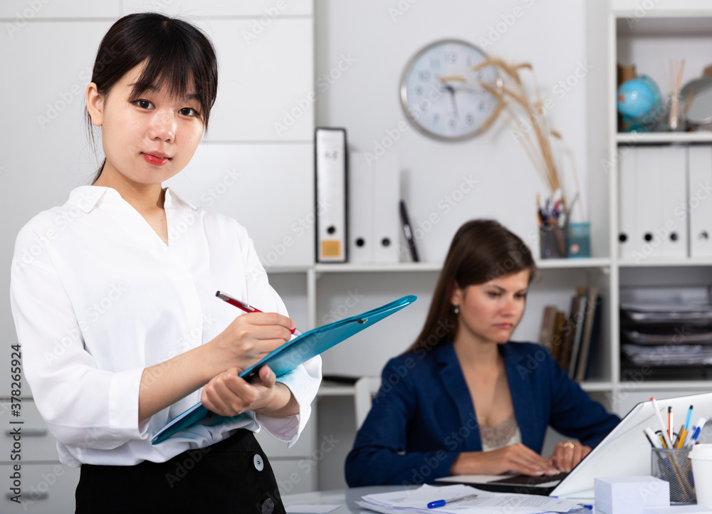 Positive asian female assistant politely welcoming to modern ...