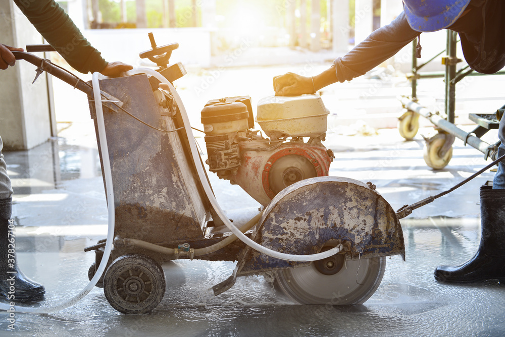 Foto de Workers using cutting machine are cutting concrete for ...