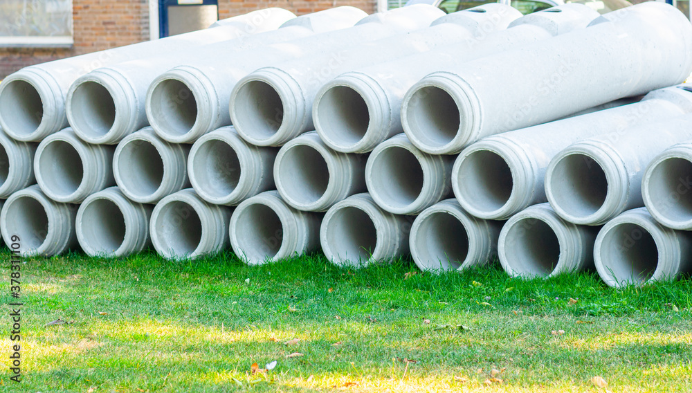concrete prefabricated pipes lying on the ground, ready for sewerage ...
