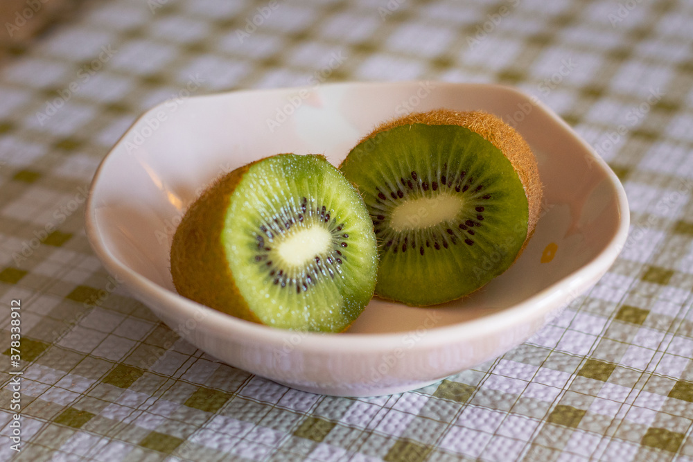 Kiwi fruit cut in half in pink bowl with skin on Stock Photo | Adobe Stock