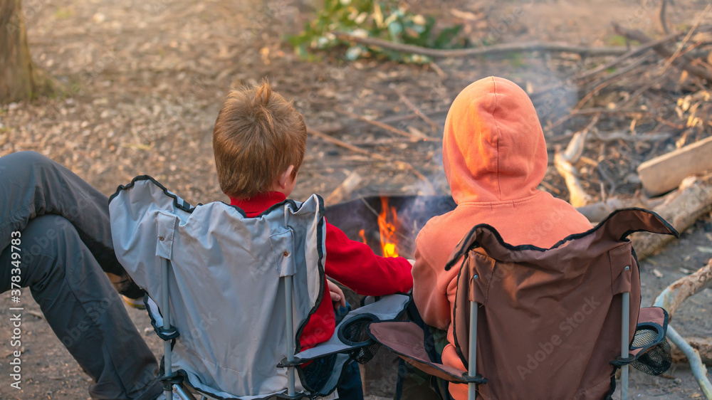 Kids burning campfire in the forest camping grounds during winter ...