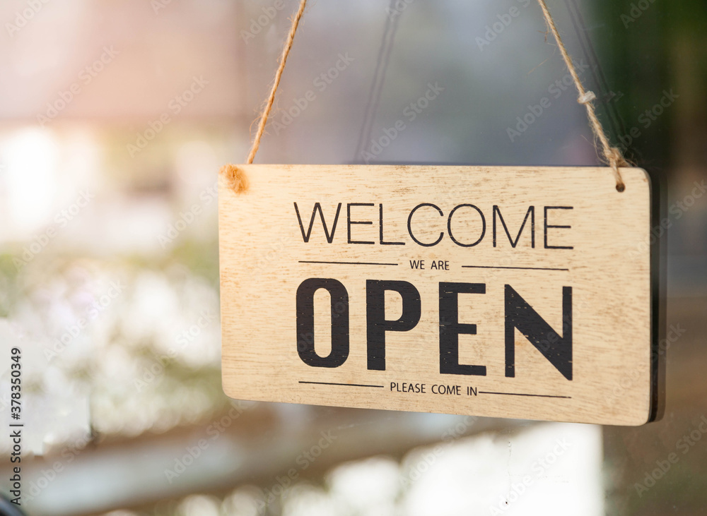 Open sign broad through the glass of door in cafe with colorful bokeh ...