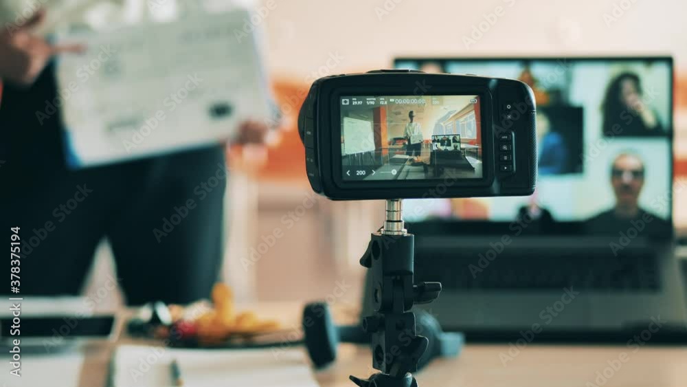 A camera is filming an online lesson of a female teacher. On-line class ...