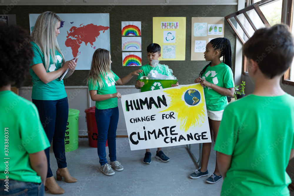 Female teacher and group of kids holding climate change banner in ...
