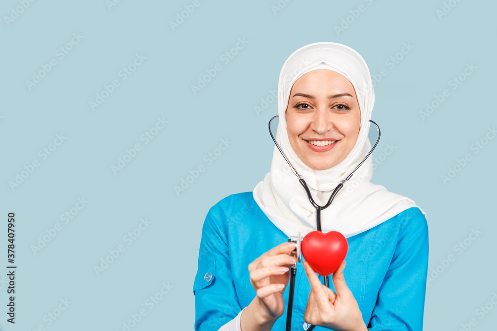 Portrait of a friendly, Muslim woman doctor or nurse with a stethoscope ...
