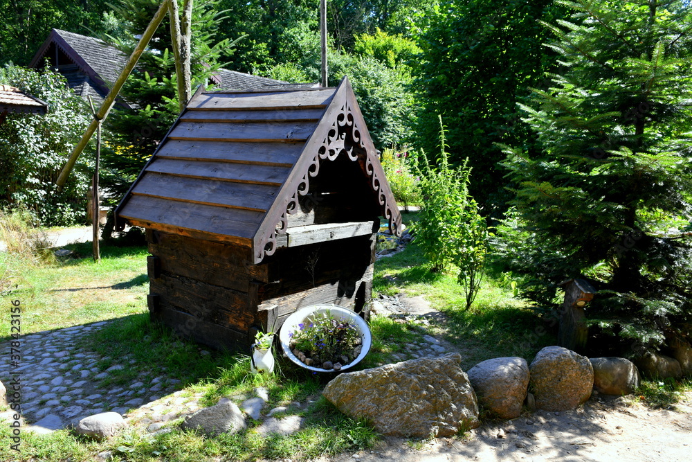 Foto de View of a small well decorated to resemble a tiny house and ...
